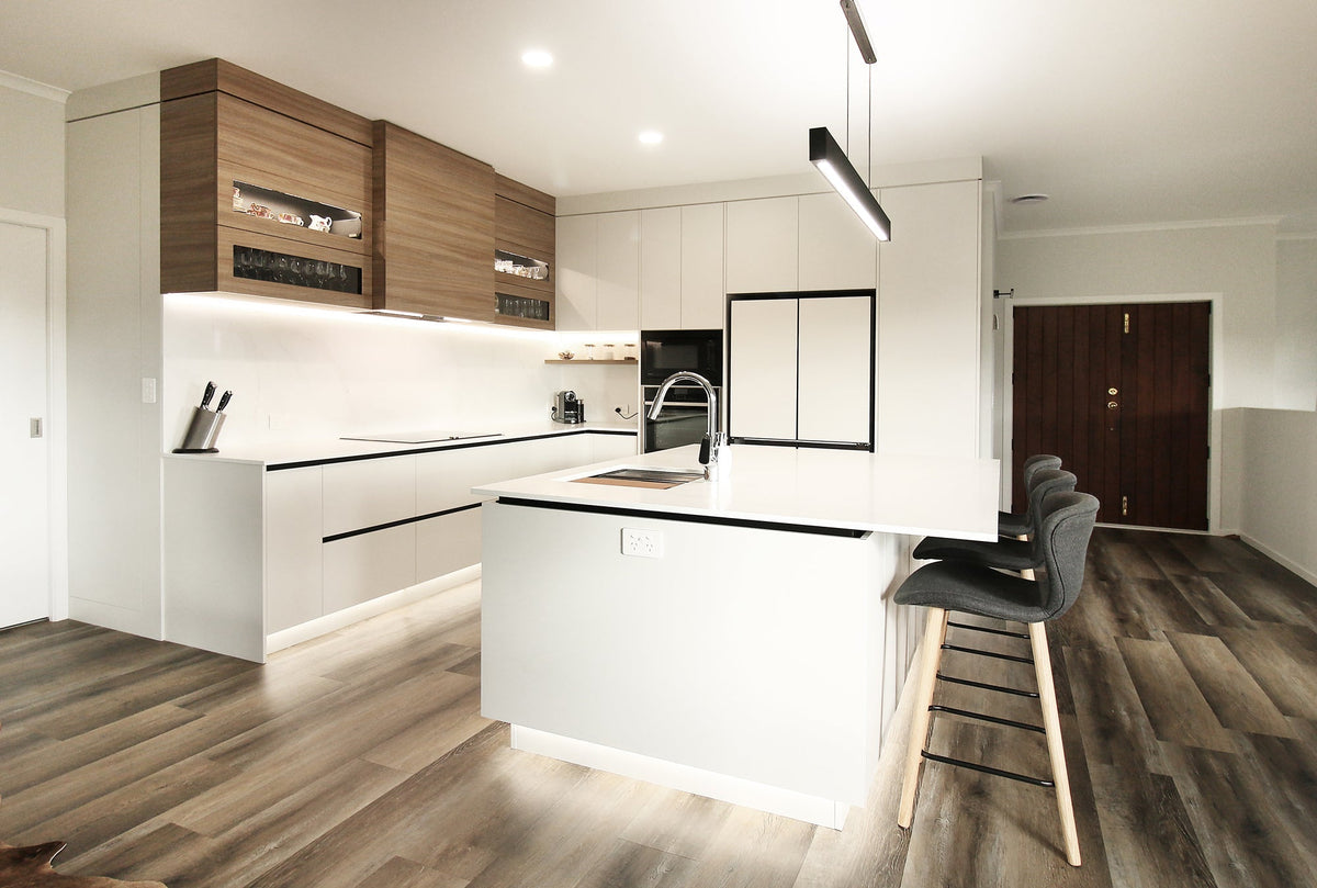 Contemporary kitchen with warm timber overhead – Total Kitchens